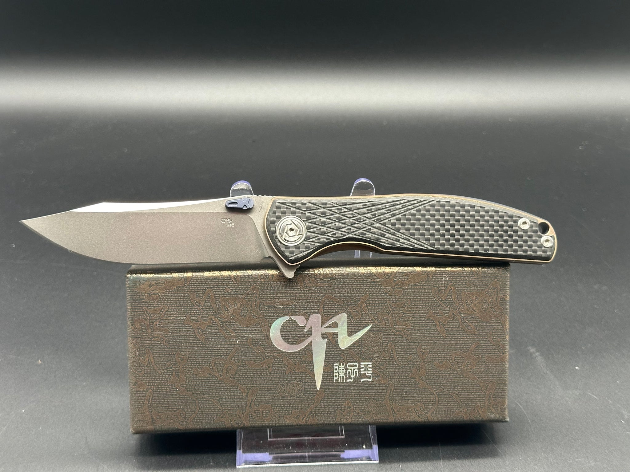 CH Knives CH3516 Bronze TI Frame, CF scales. Blue thumb studs, back sp